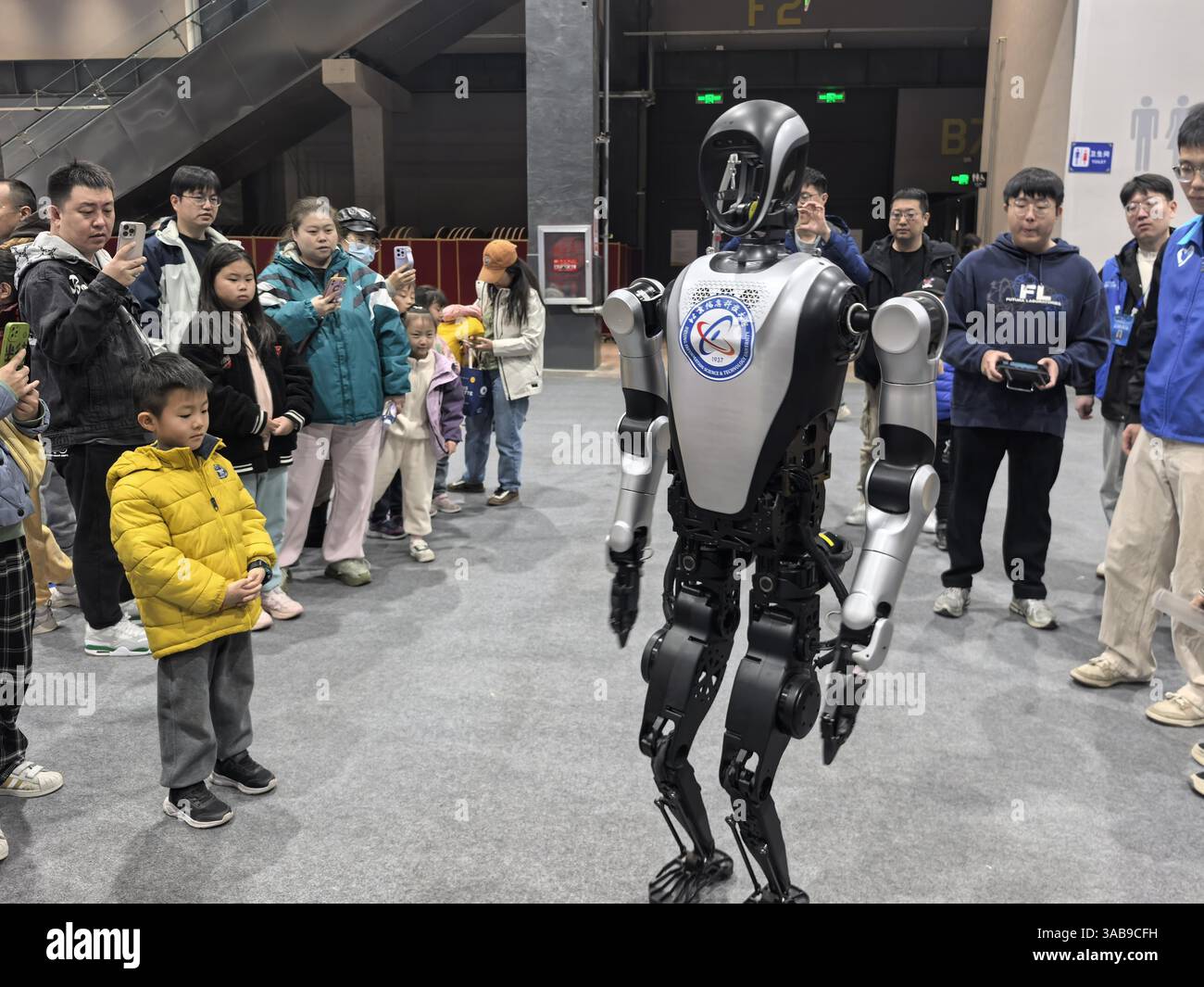 People interact with a humanoid robots in Beijing, China, 29 March ...