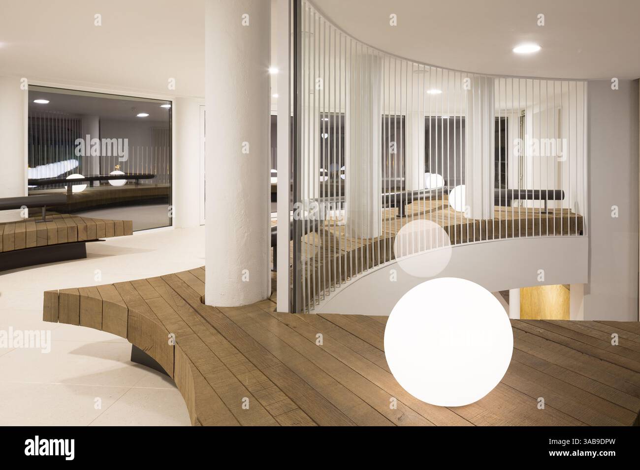 A modern interior lounge in club featuring curved wooden benches, sleek ...