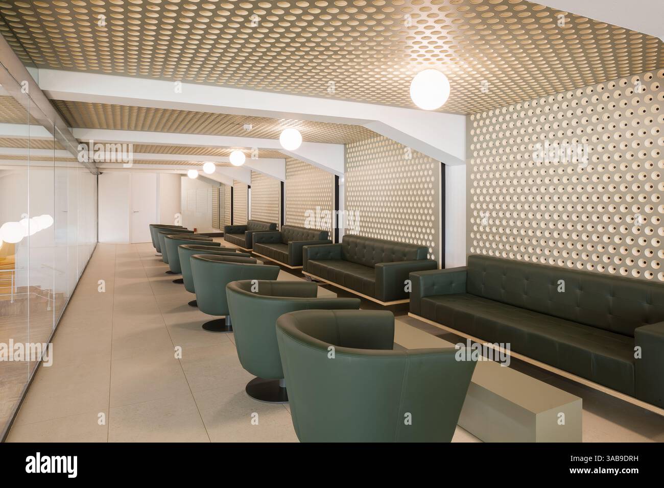 A contemporary lounge in club featuring sleek green chairs and couches ...