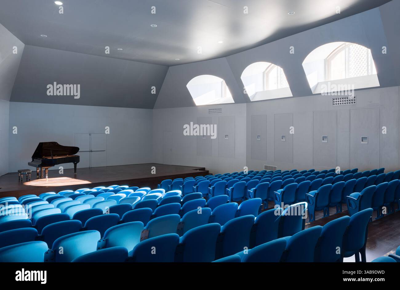 Empty auditorium with vibrant blue seats facing a stage with a grand ...