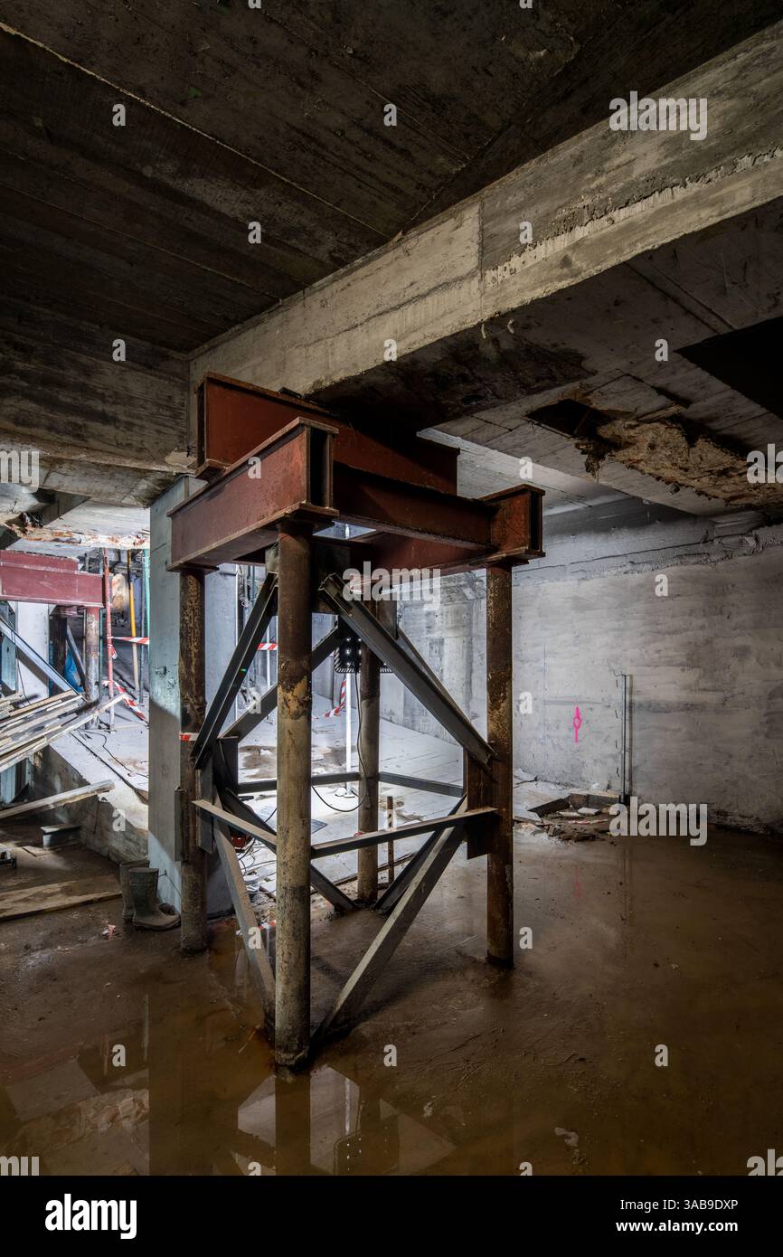 A construction site features exposed metal beams and concrete ...