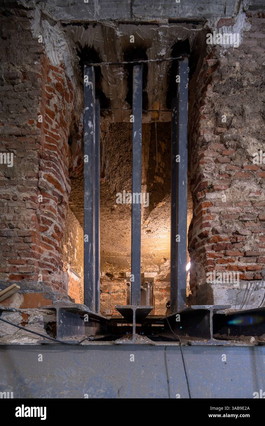 Exposed steel beams integrate with rough brickwork, highlighting ...