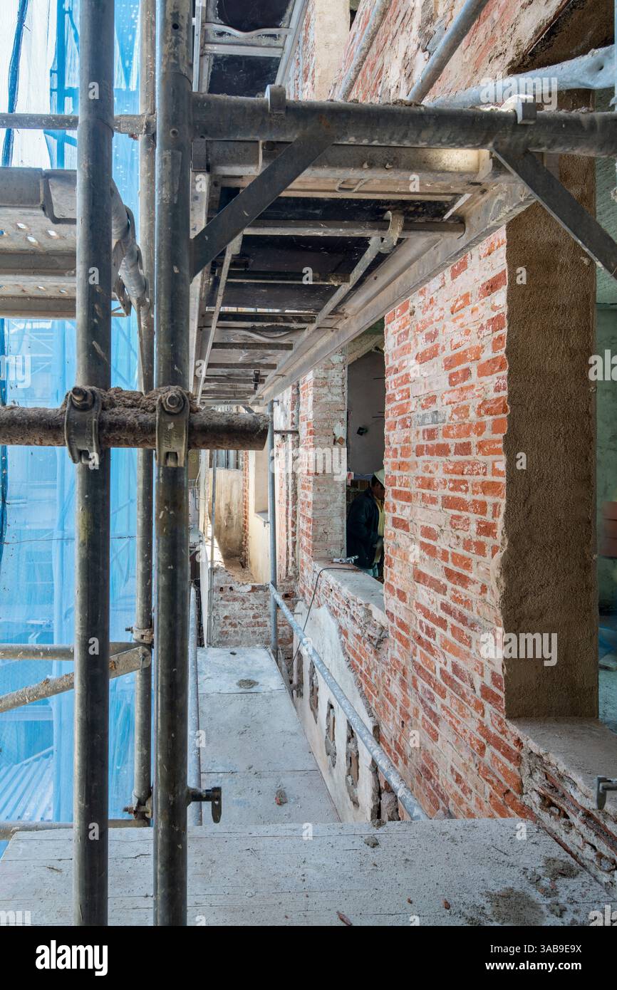 Scaffolding surrounds a building under renovation, showcasing exposed ...
