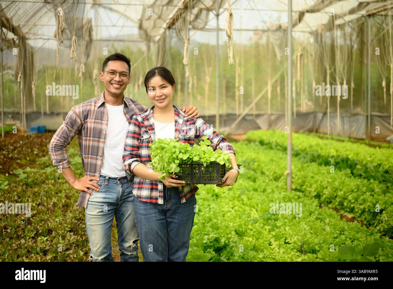 Agricultural entrepreneurs standing together in their vegetable farm ...