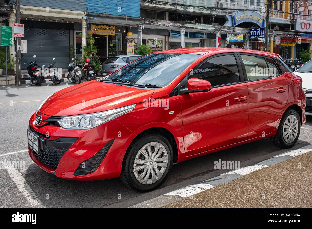 Toyota hatchback car parked on an urban street beside a white line on ...