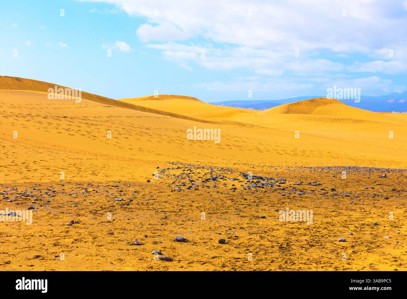 Golden dunes stretch under a vibrant blue sky, creating a breathtaking ...