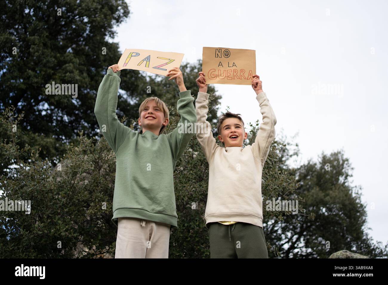 Two happy children holding protest signs asking for peace and against ...