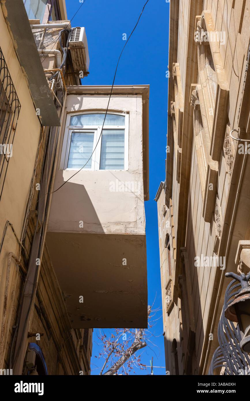 Narrow street view with a balcony under blue sky, vertical photo taken ...