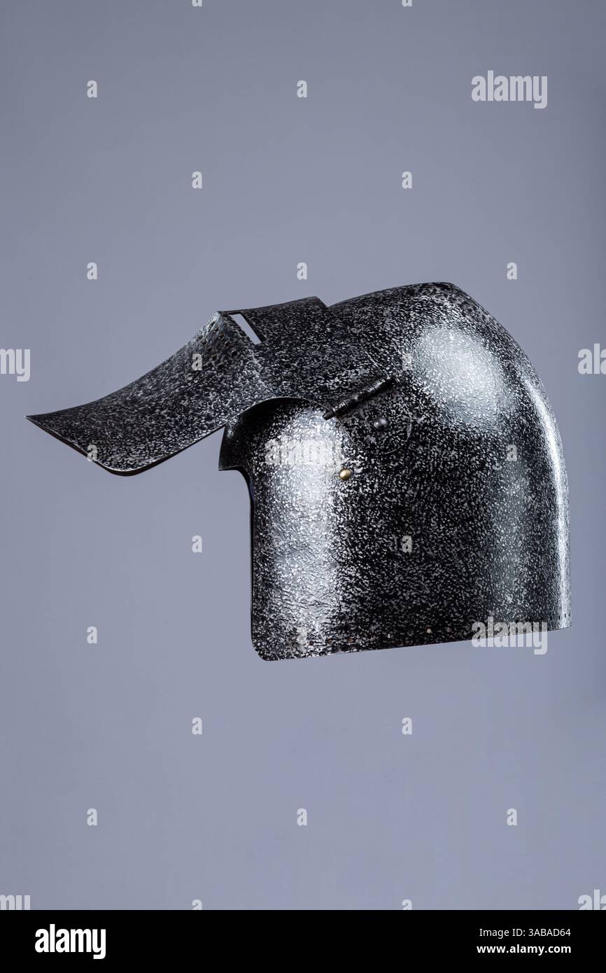 Darkened Steel Medieval Helmet Cheek Piece. Side view of battle-worn ...