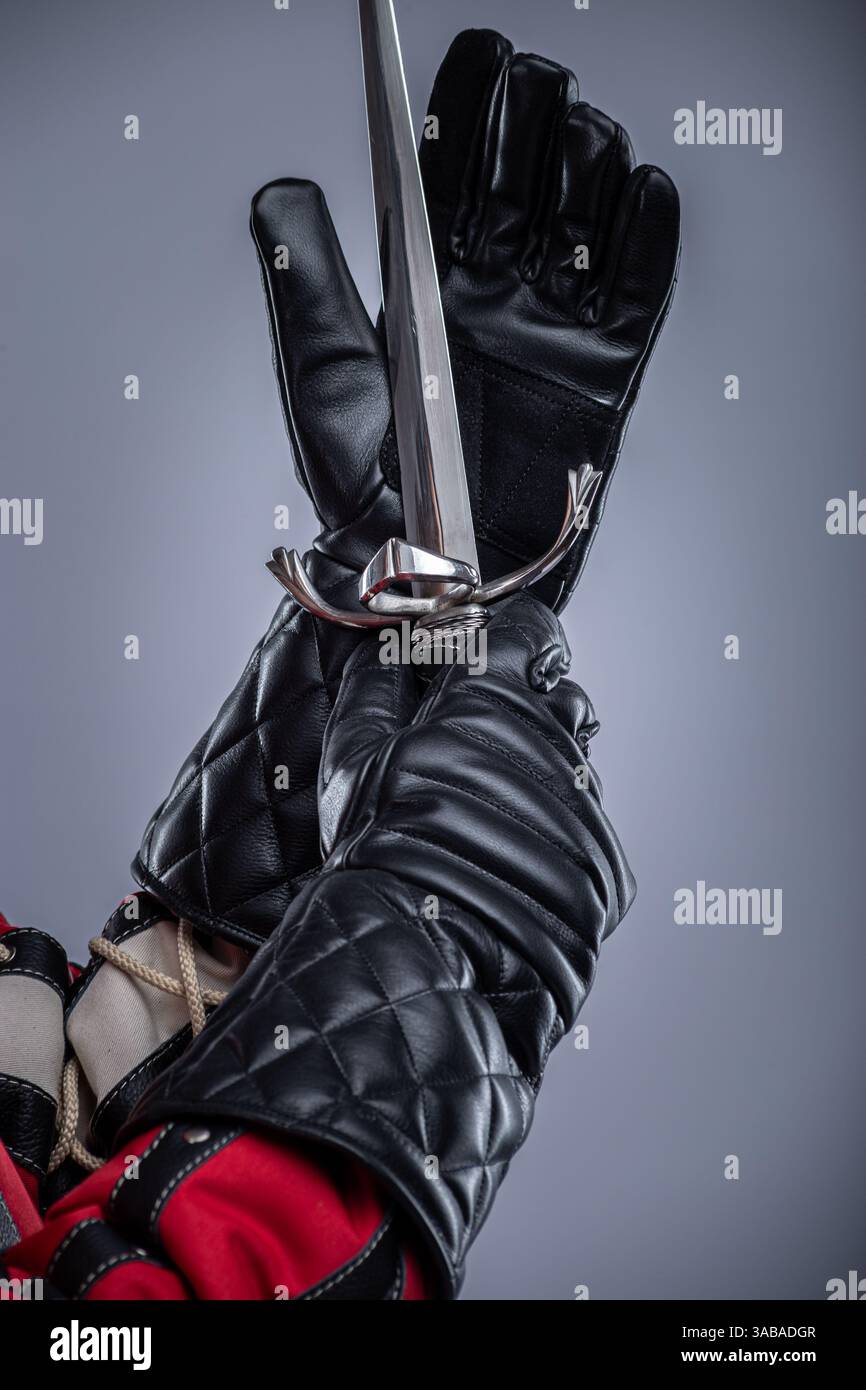 Close-Up of Hands in Black Gloves Holding a Blade. This image provides ...