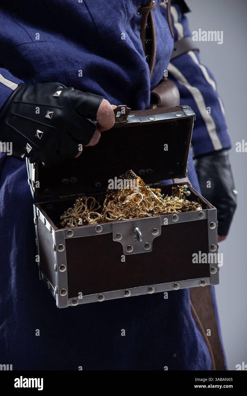 Open Treasure Chest Overflowing with Gold. Close-up of a hand revealing ...
