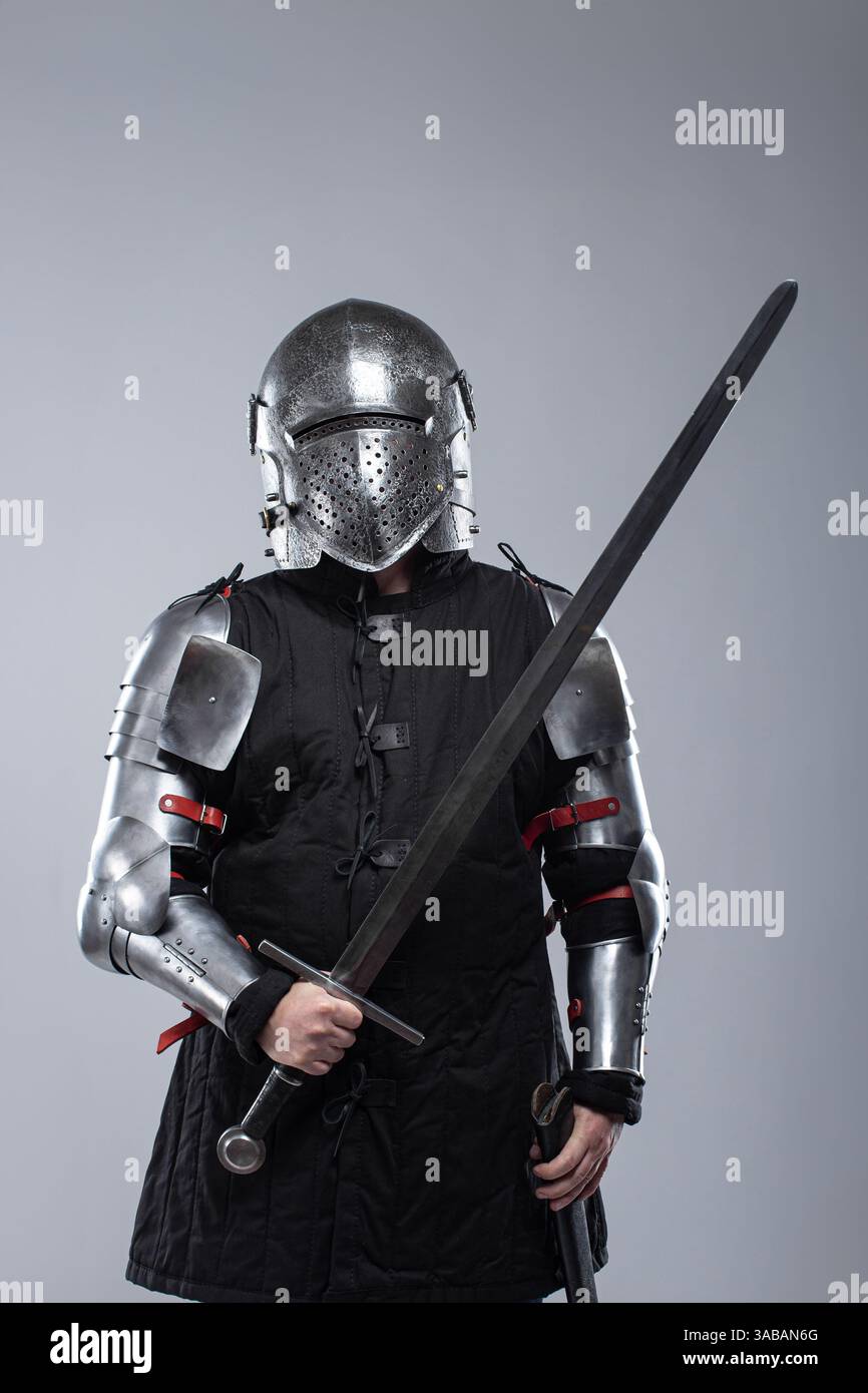 Knight in Full Plate Armor Holding a Sword. This image shows a person ...