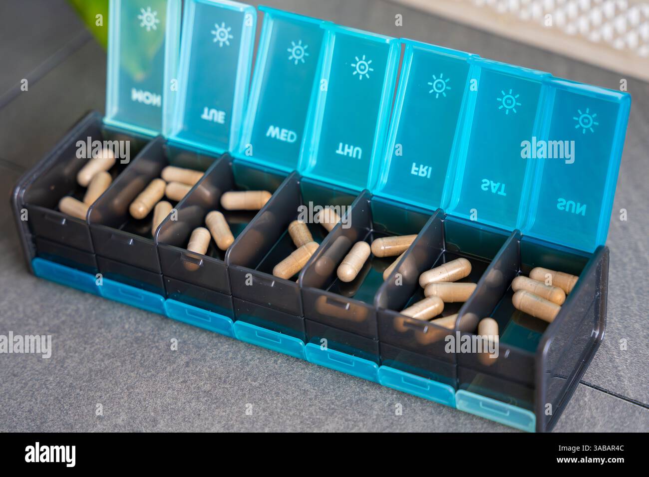 Weekly pill organizer with labeled compartments for daily medication ...