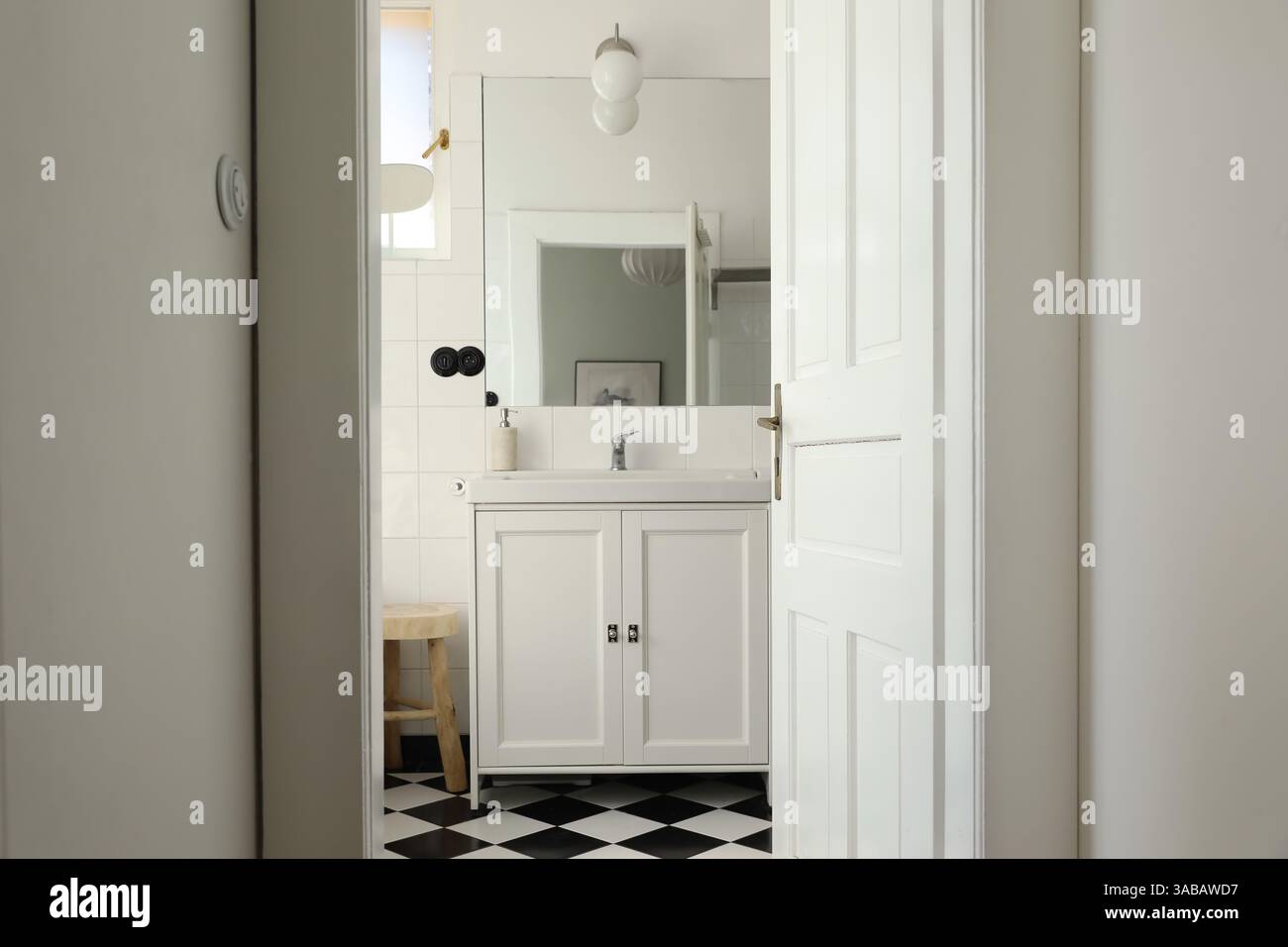 Retro elegant bathroom interior through open door. Wash basin, cabinet ...