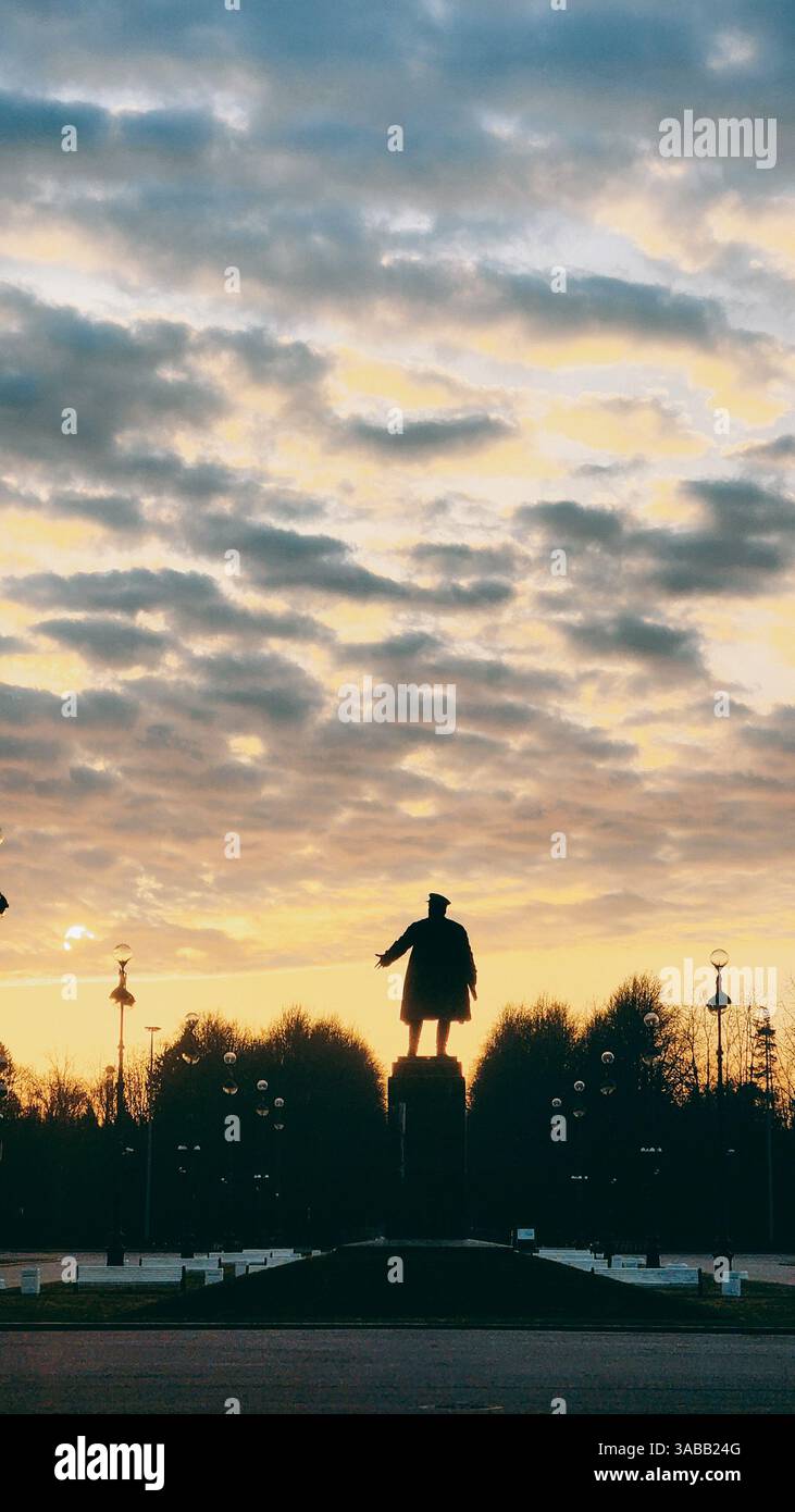 Silhouette of a statue against a vibrant sunset sky with scattered ...