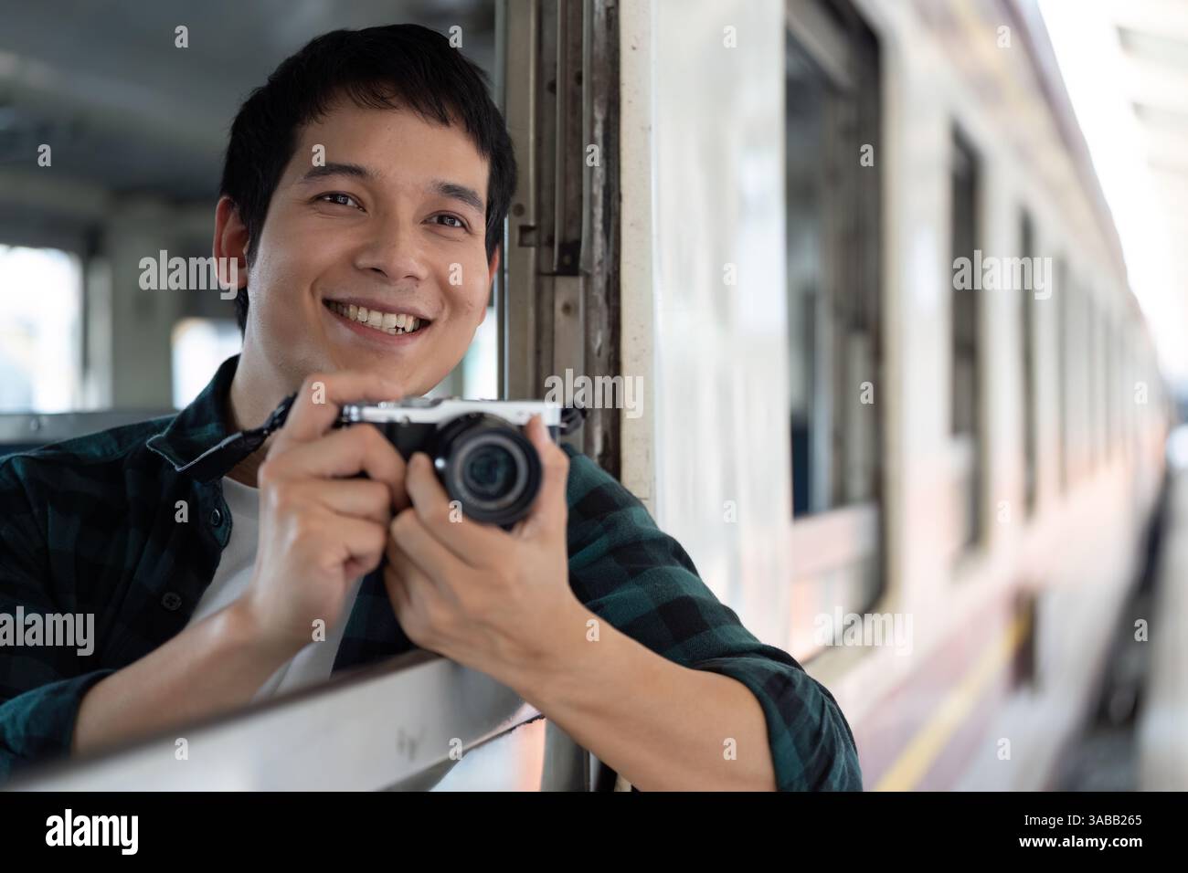 Adventure and Creativity. A cheerful traveler poses with his camera at ...