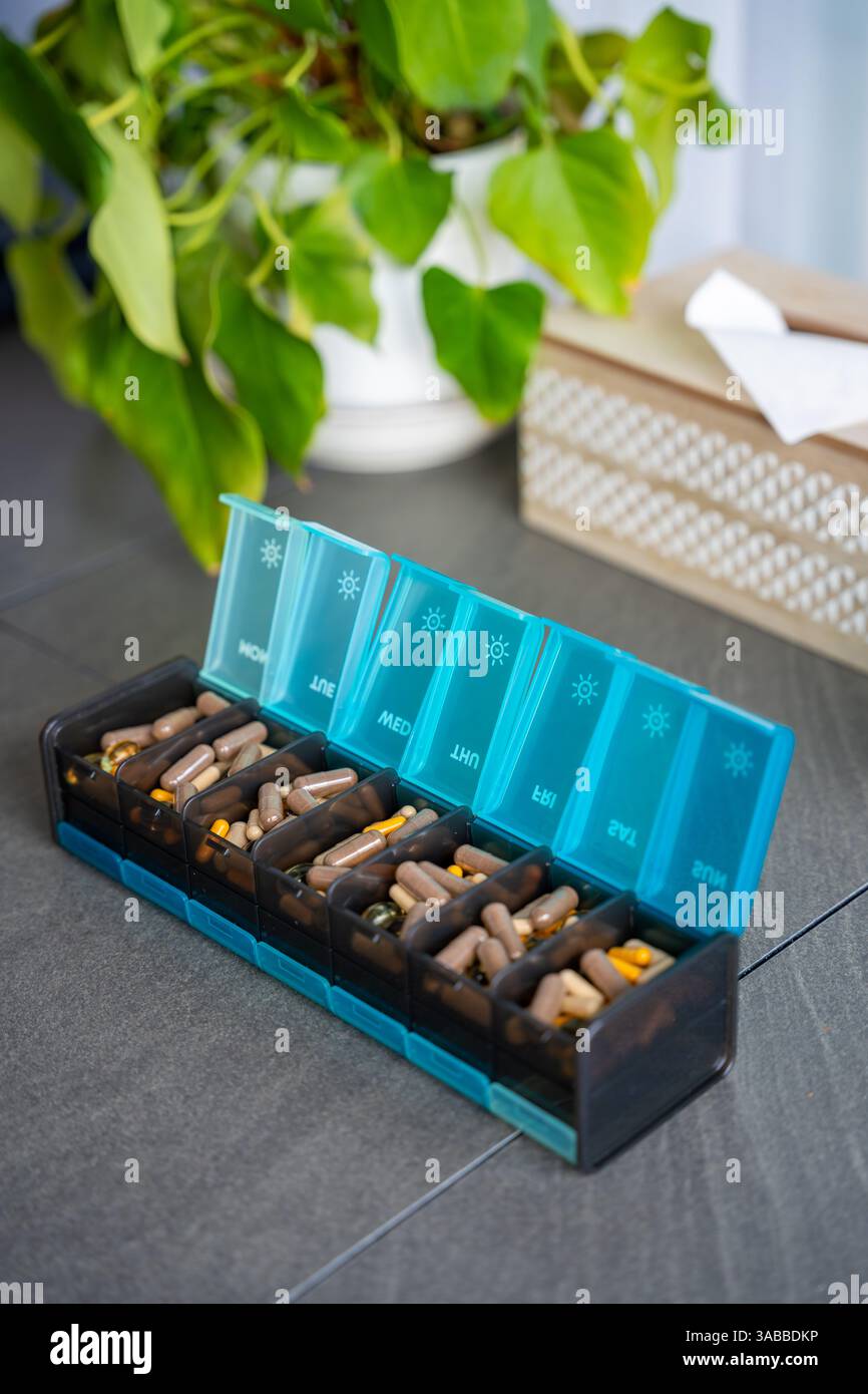 Weekly pill organizer with labeled compartments for daily medication ...