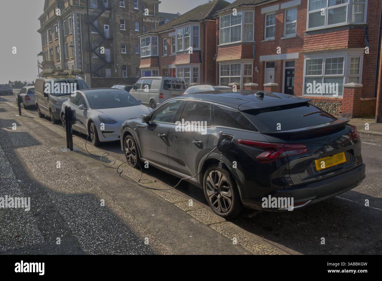 Electric vehicle being charged from public charger in urban street ...