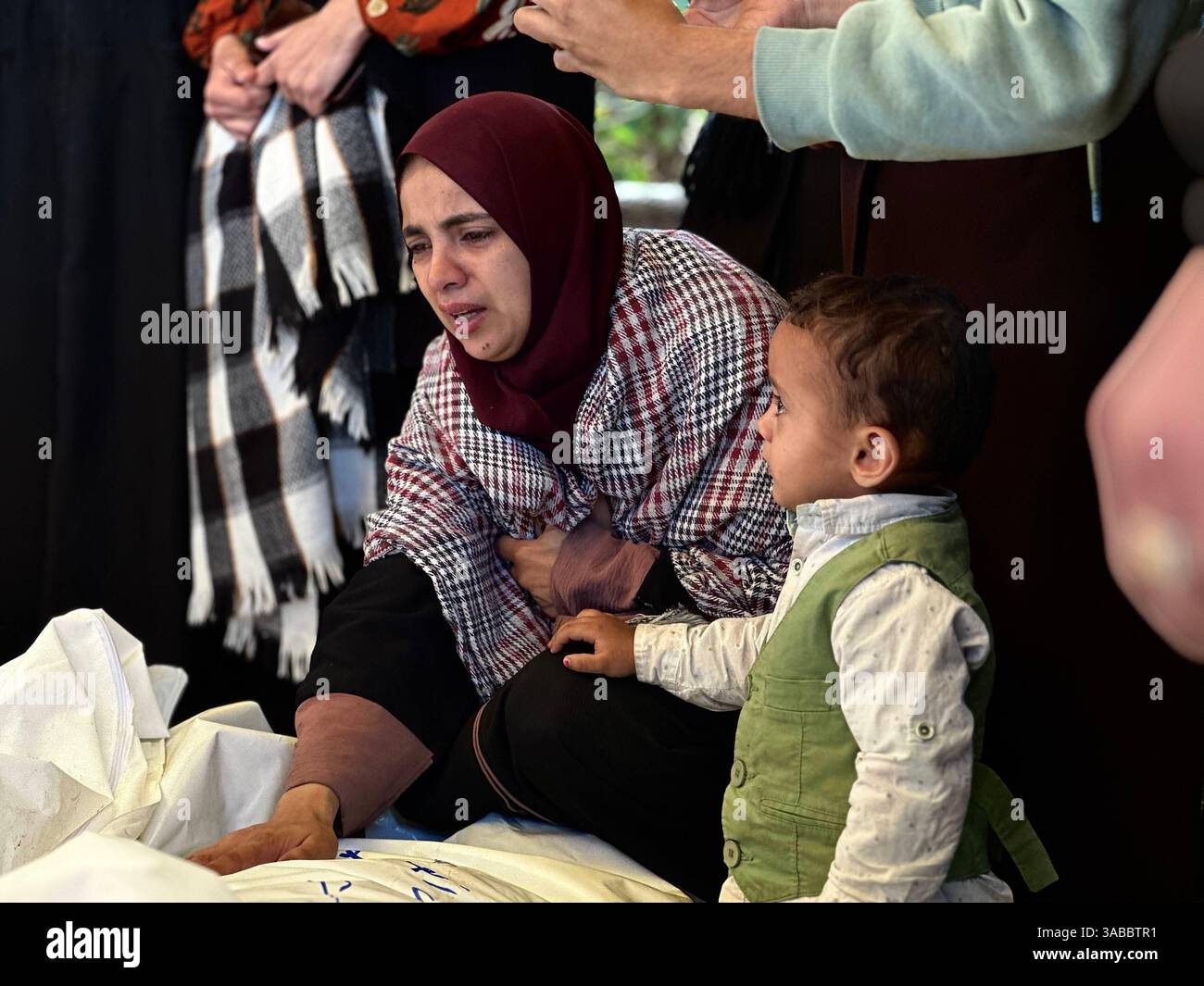 Palestinians mourn over the bodies of Abu Qaoud family killed in Israeli strikes, before a ...