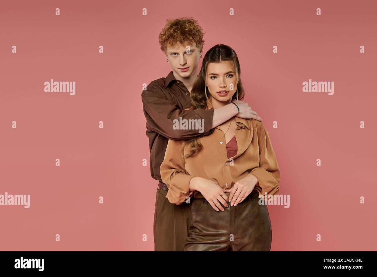 Vibrant couple joyfully bonding, dressed in trendy attire against a ...