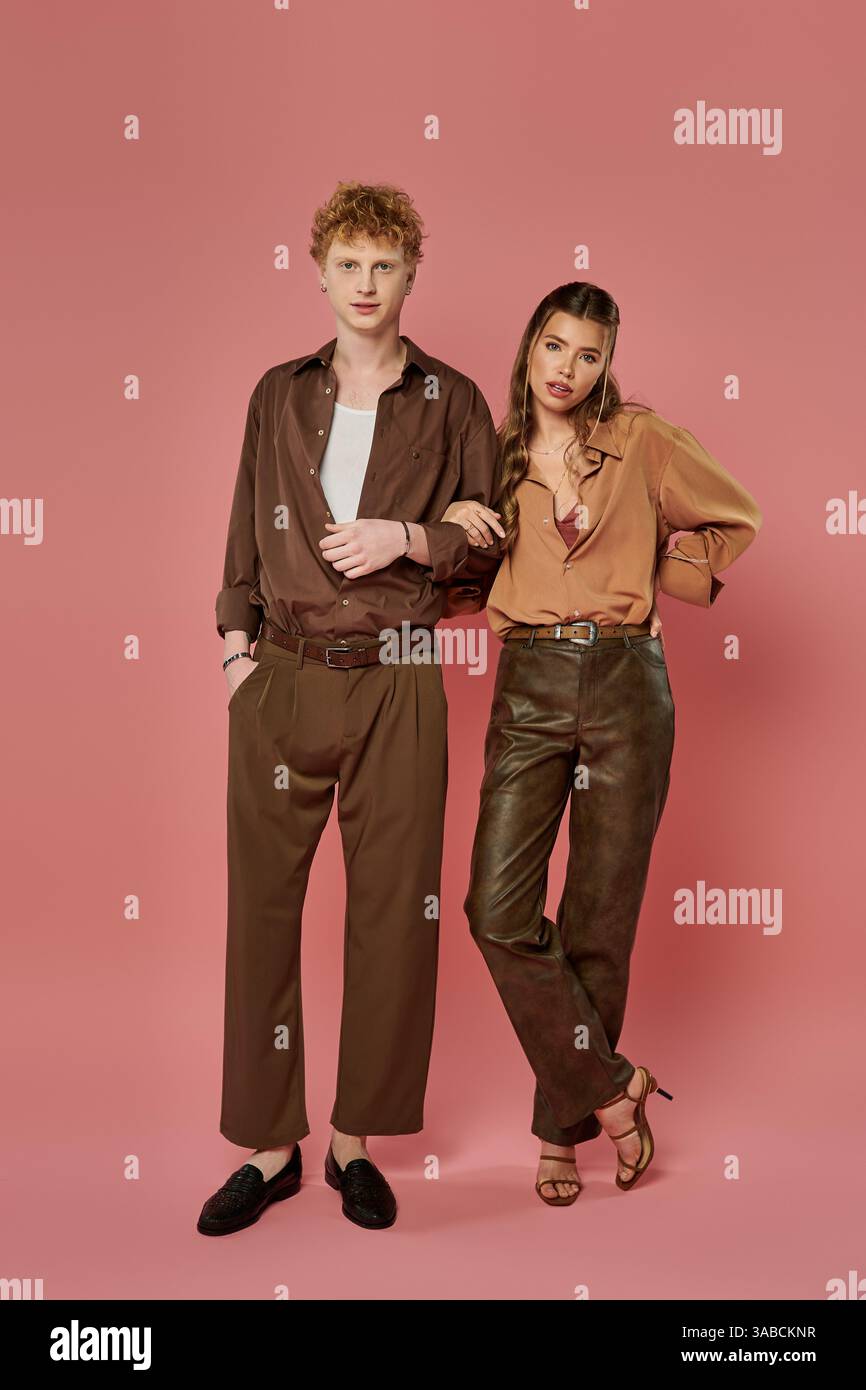 A young couple dressed in trendy outfits enjoys a joyful moment ...