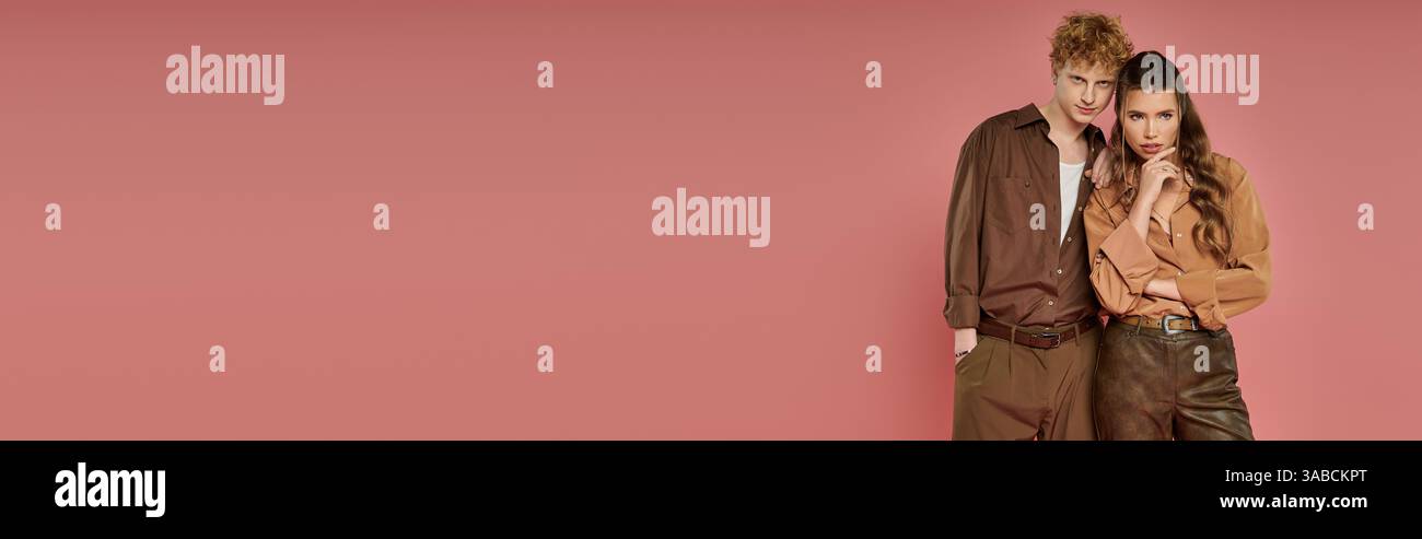 A chic couple stands close, highlighting their fashion sense and strong ...