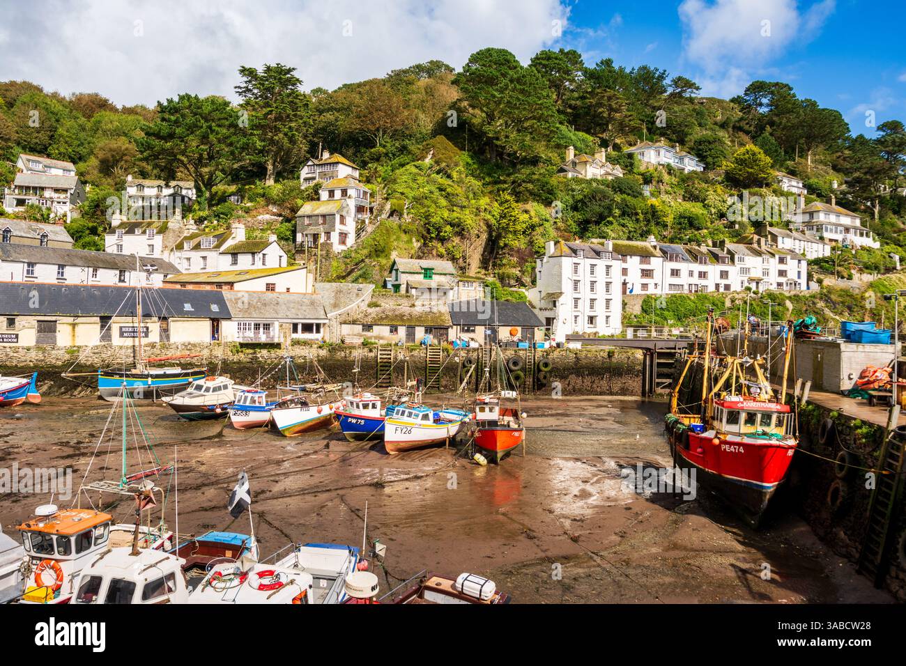 Fishing boats grounded in Polperro harbour at low tide, showcasing the ...