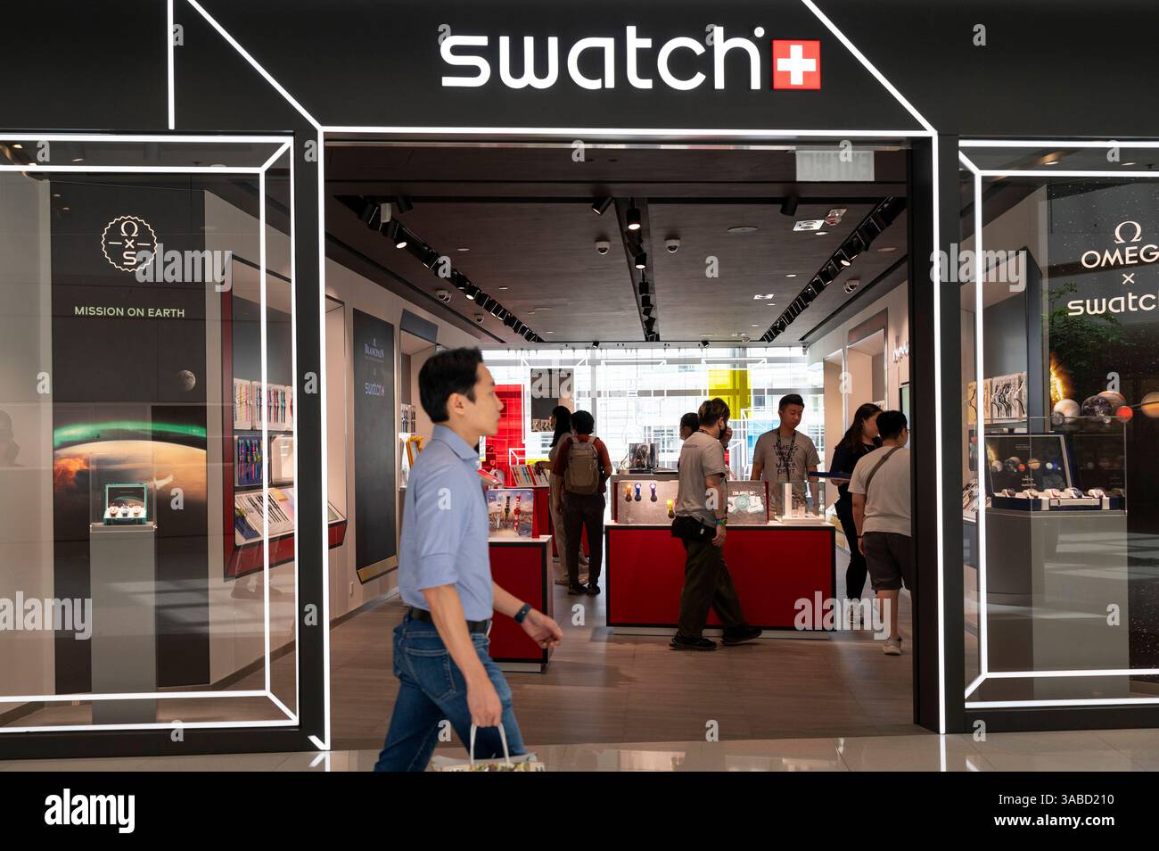 A man walks past the Swiss multinational watchmaker Swatch brand store ...