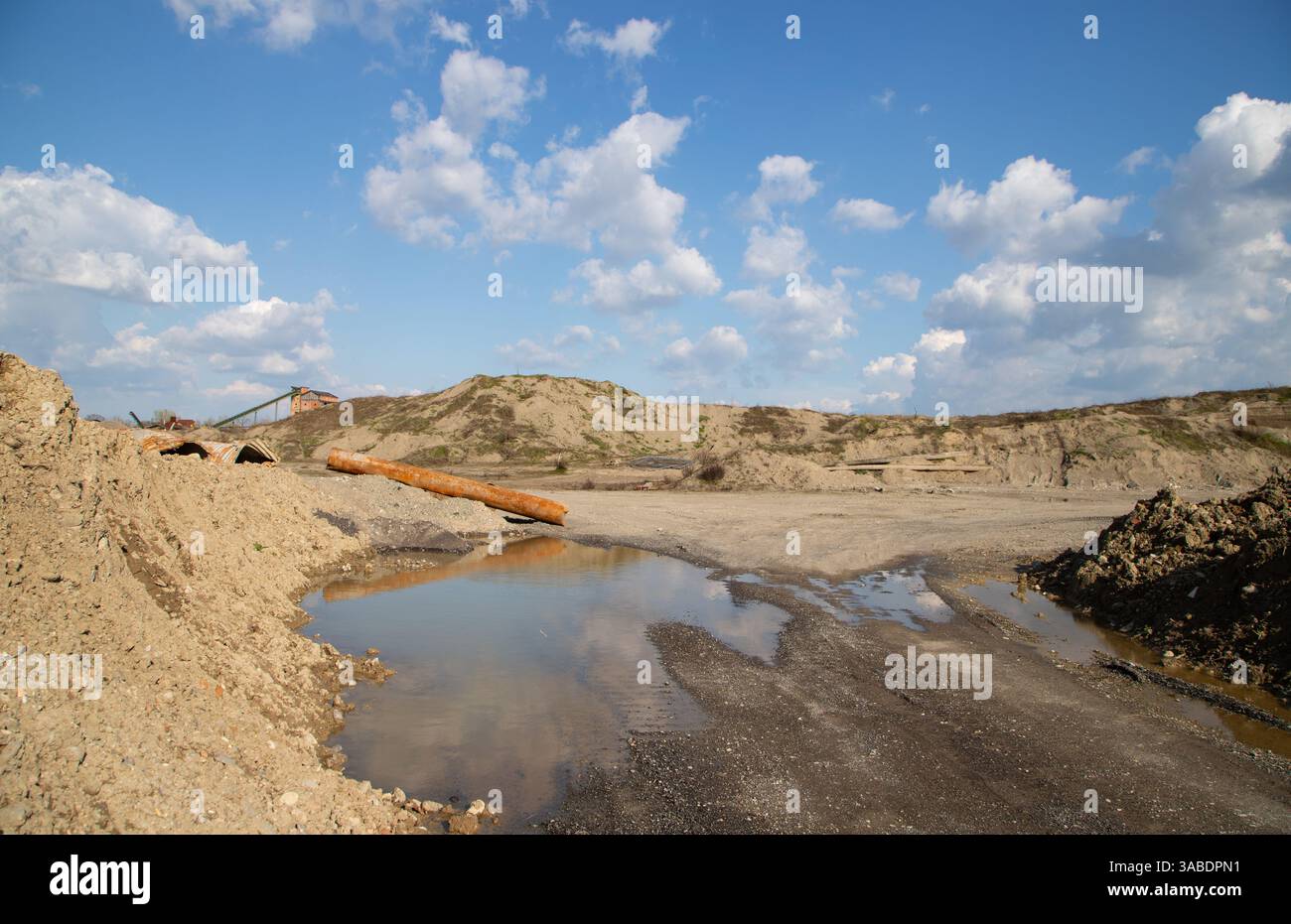 Old gravel and sand pile by a river, with a disused crusher nearby ...