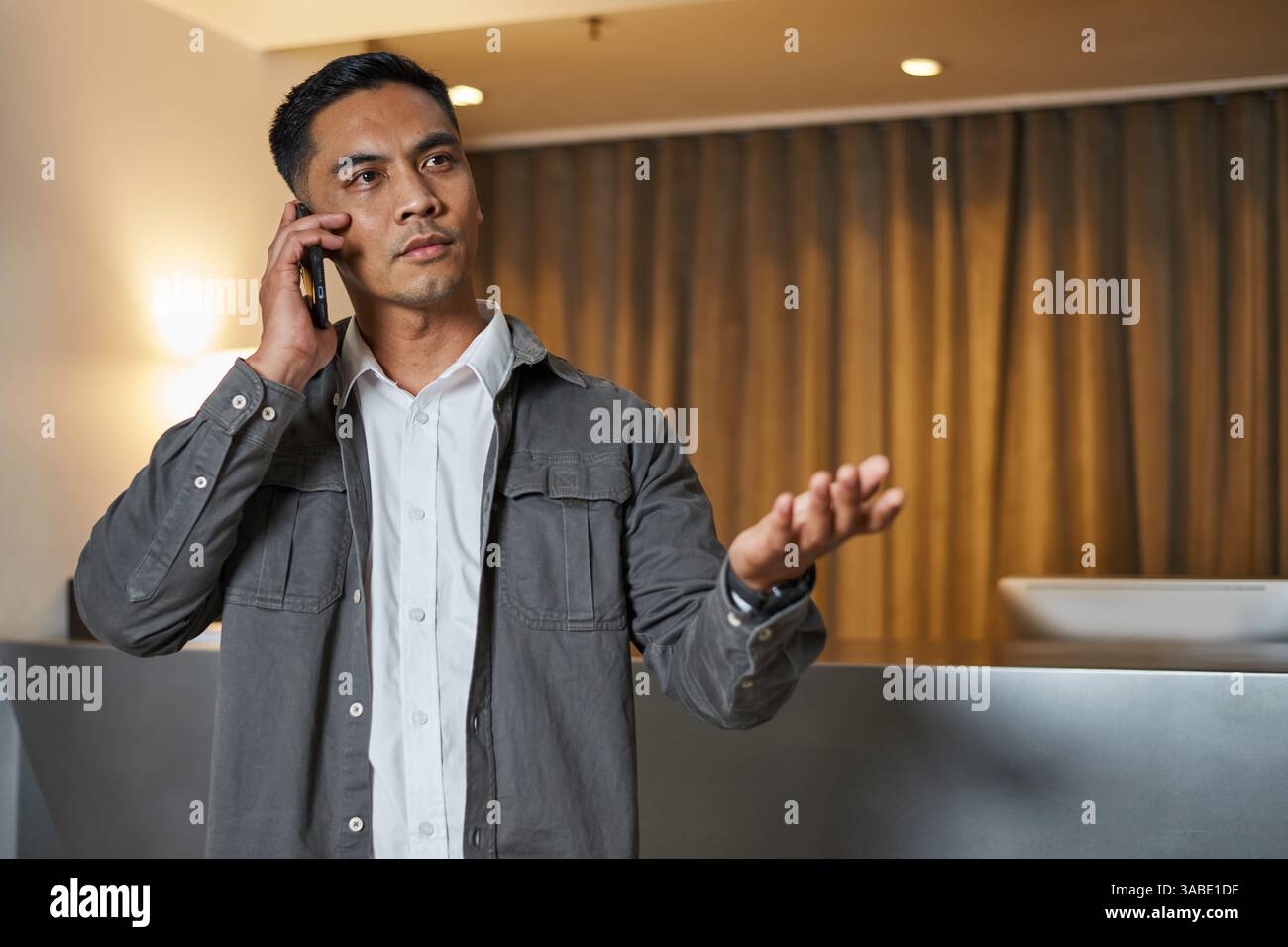 Businessman Engages in a Phone Conversation at a Modern Hotel Lobby ...