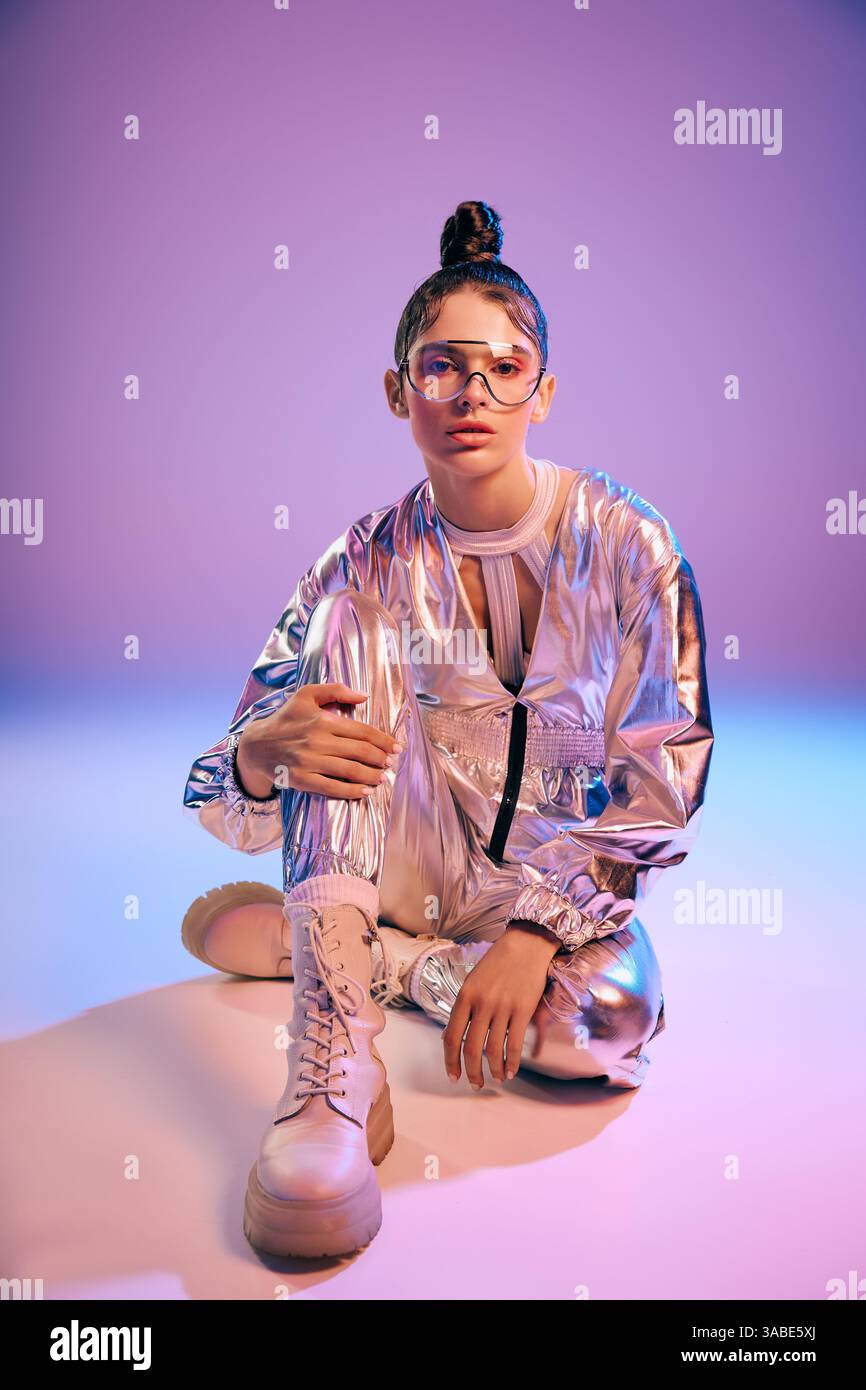 A graceful young woman models her stylish holographic outfit and trendy ...