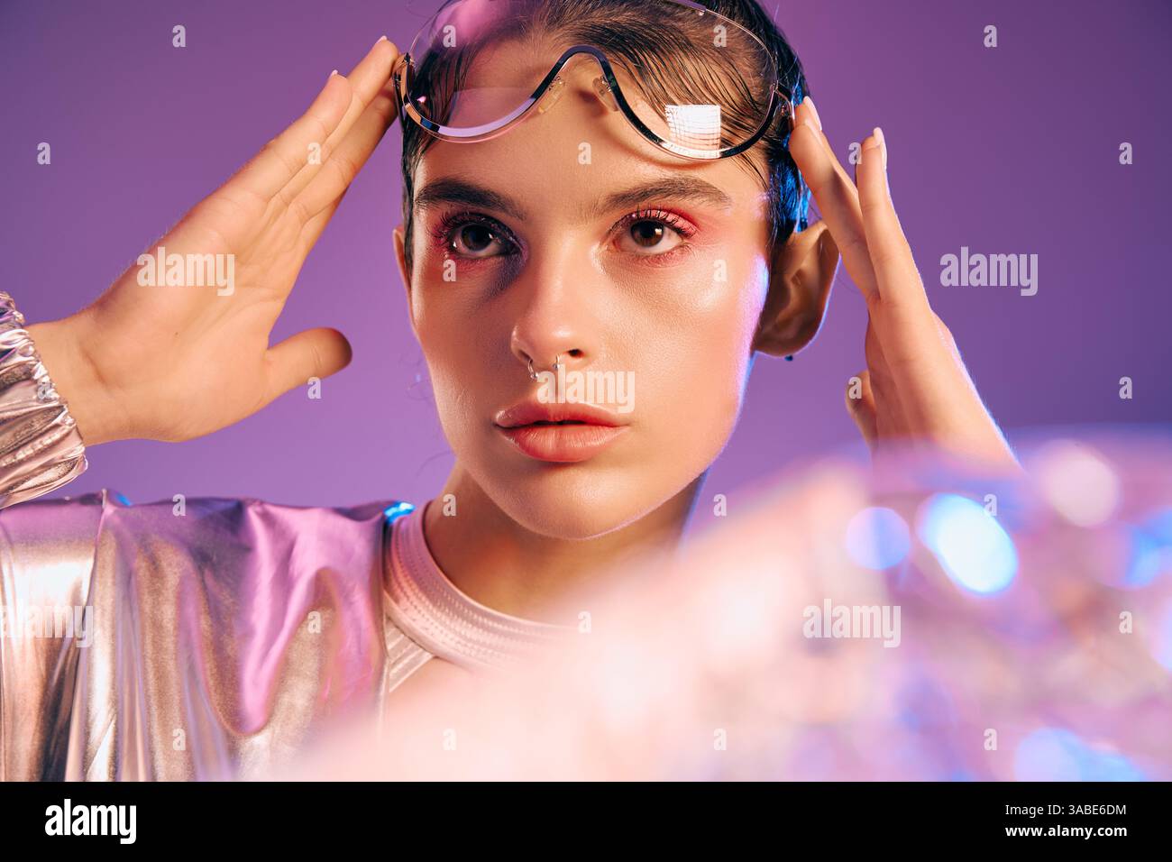 A stylish woman in futuristic attire showcases holographic colors with ...