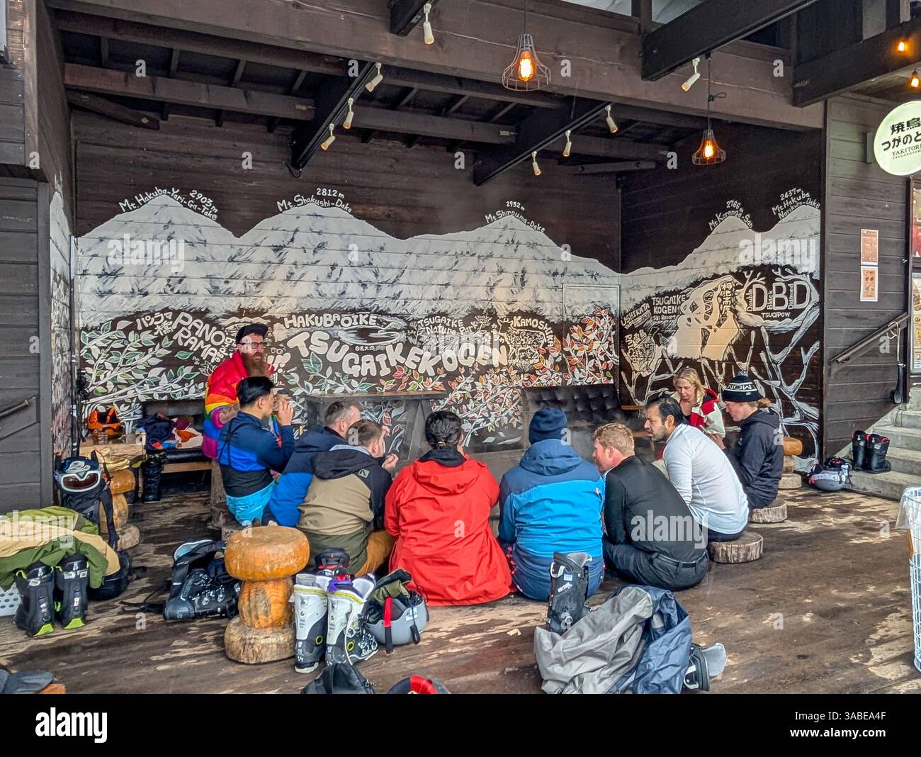 Groups of skiers and snowboarders relaxing at a hot spring footbath at ...