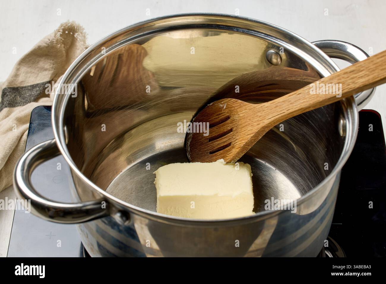butter is being melted in a pot. Process of making french onion soup ...