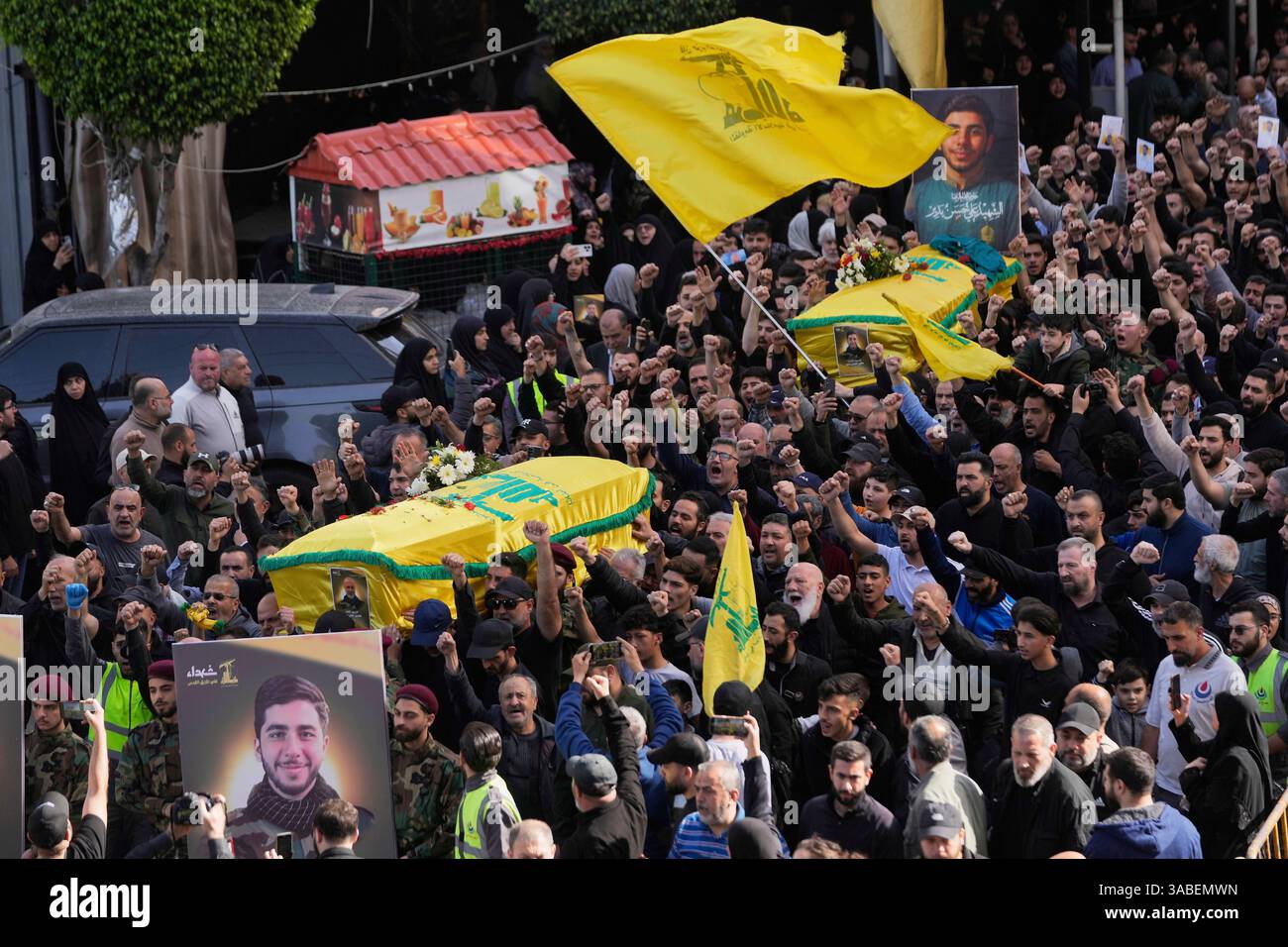 Mourners carry the coffins of Hezbollah official Hassan Bdeir and his ...