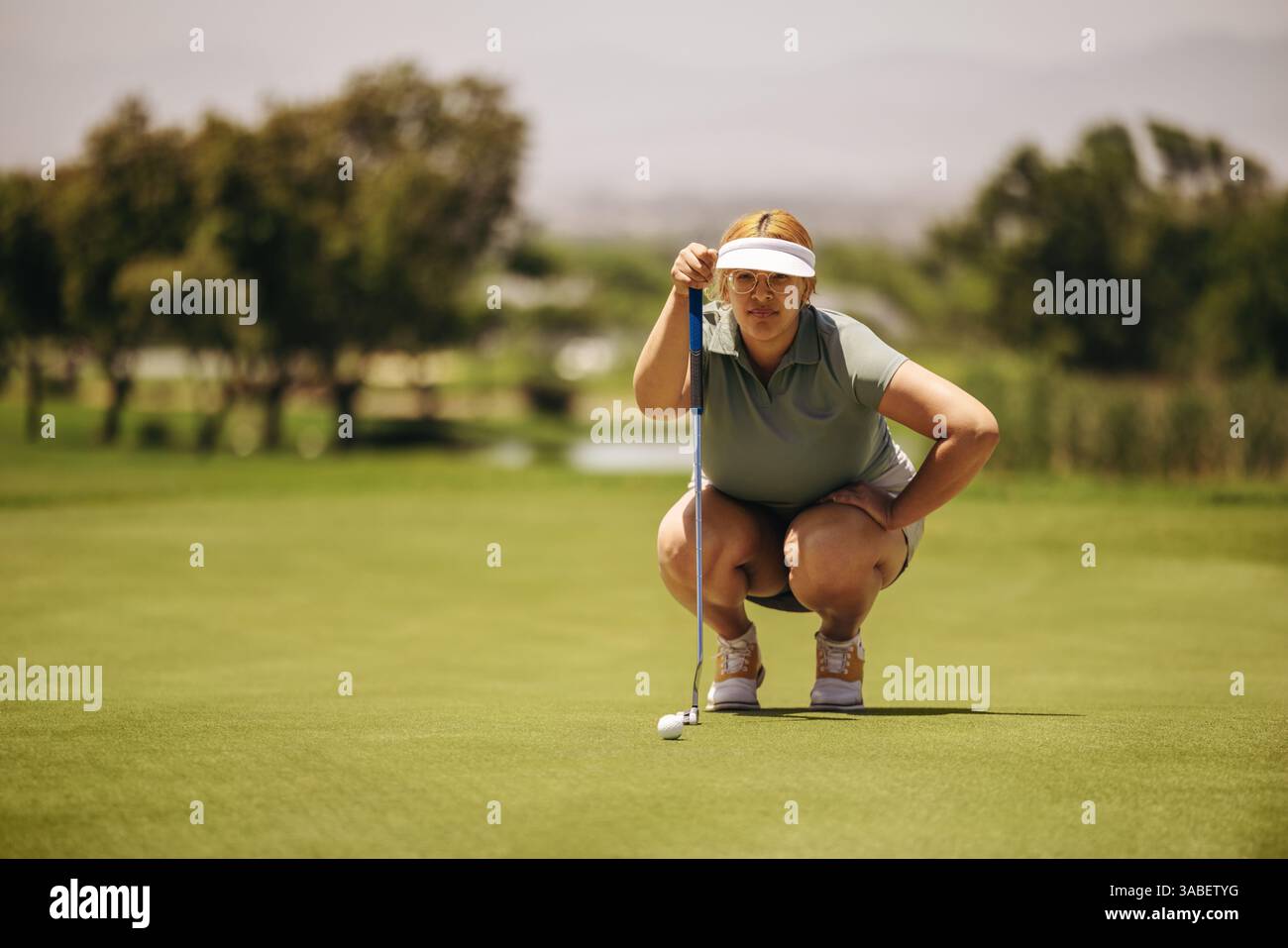 With the sun shining overhead, a determined sportswoman crouches on the ...