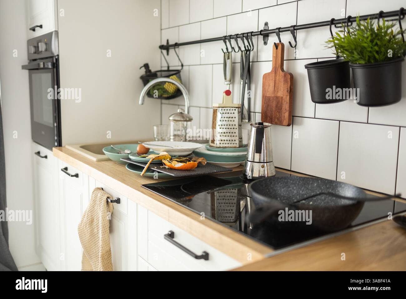 Messy kitchen with dirty dishes and food scraps on the counter after ...
