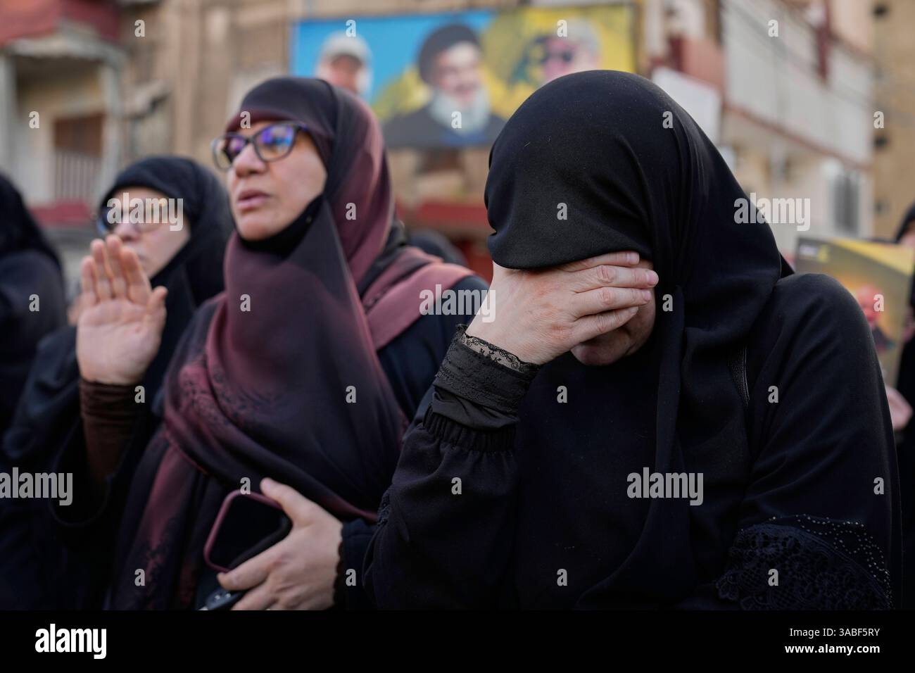 Women mourn during the funeral procession of Hezbollah official Hassan ...