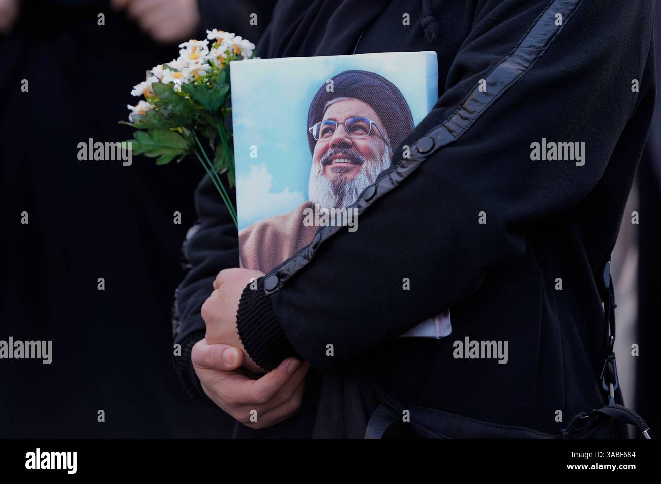 A woman holds a portrait of late Hezbollah leader Sayyed Hassan ...