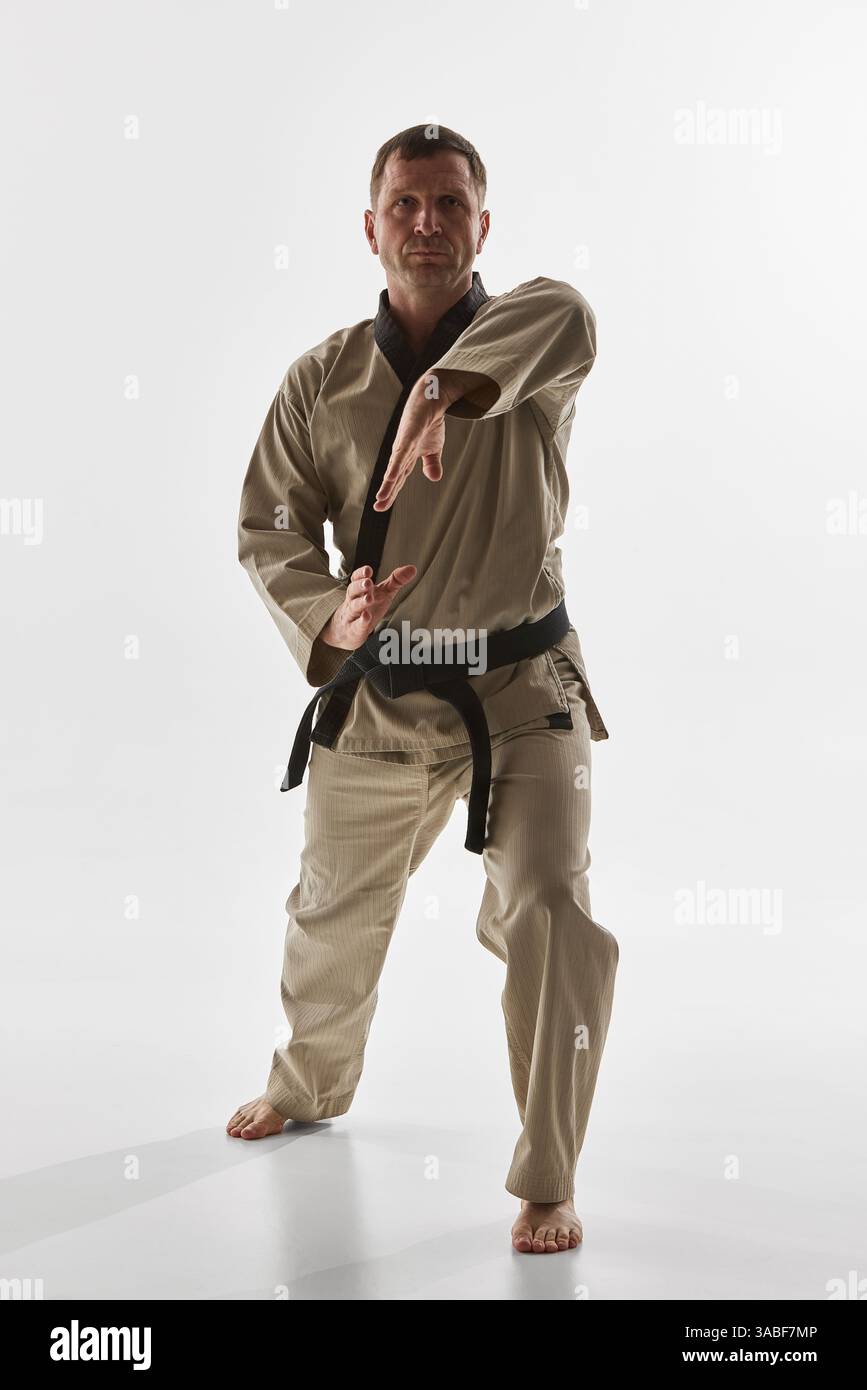 Martial artist, man in forward stance with extended arm ready to strike ...