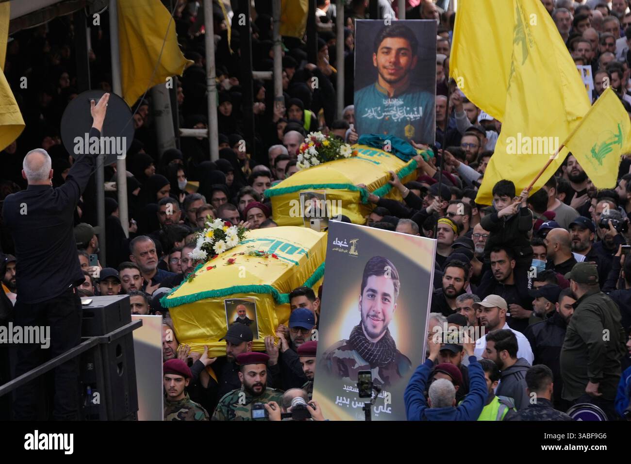 Mourners carry the coffins of Hezbollah official Hassan Bdeir and his ...