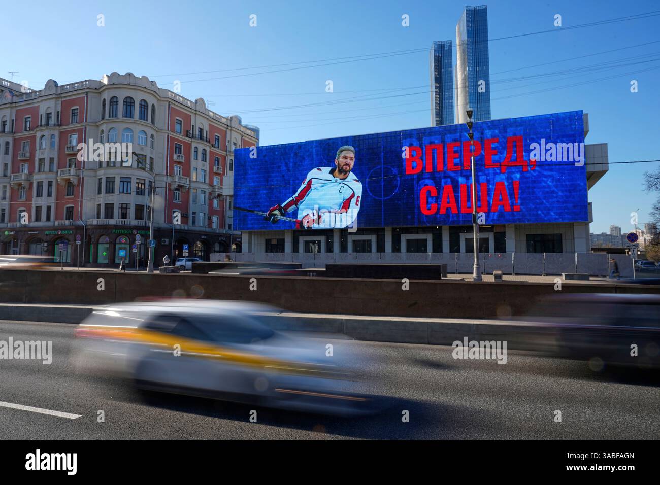 Cars drive past a screen depicting Washington Capitals' Alex Ovechkin ...