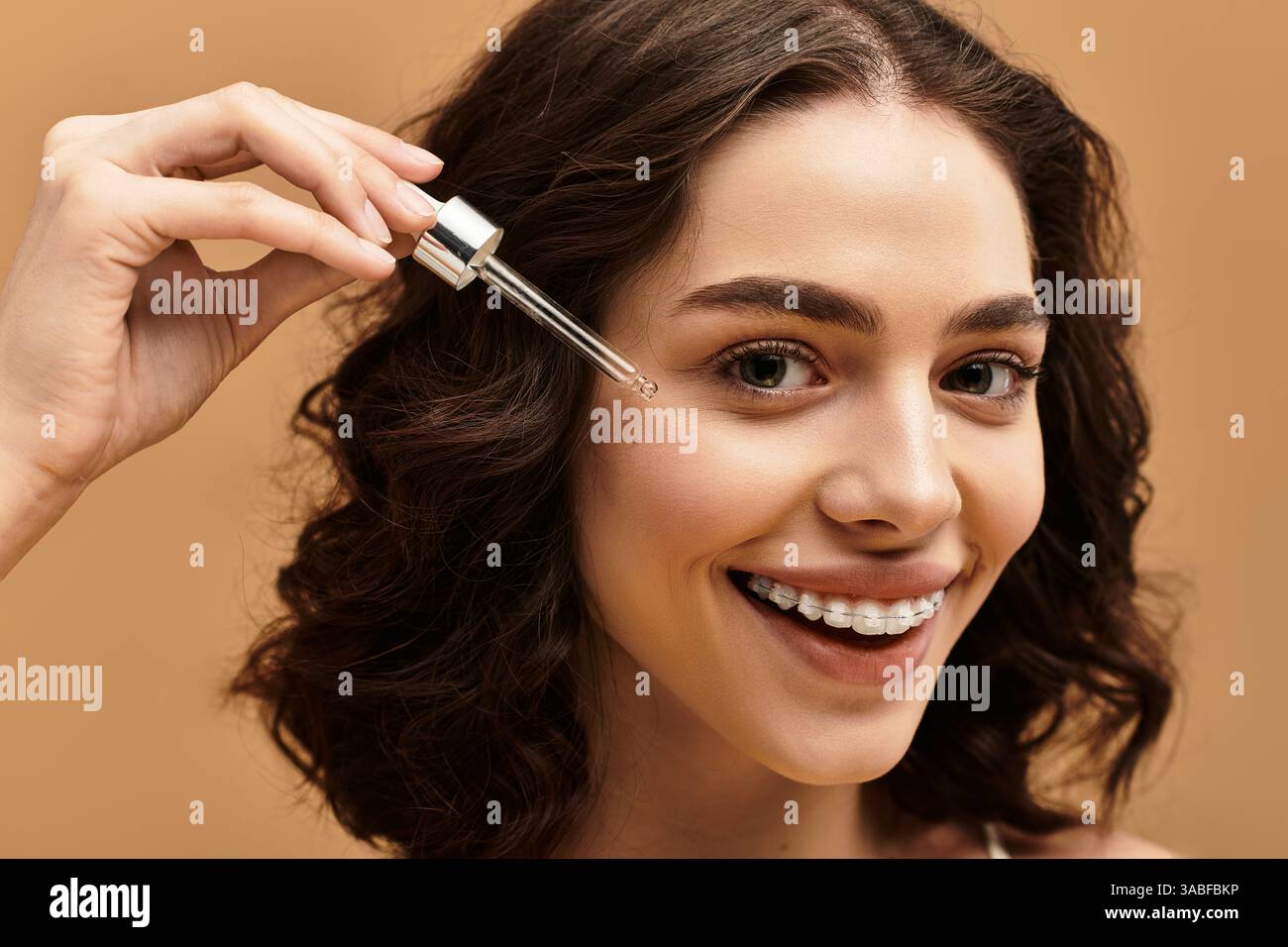 This young woman highlights her skincare routine using a serum while ...