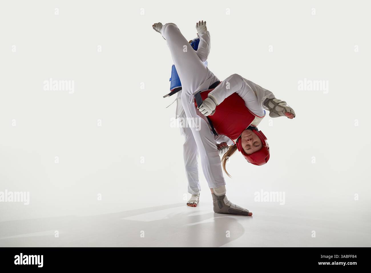 Female taekwondo fighters in motion with dramatic high kick and ...