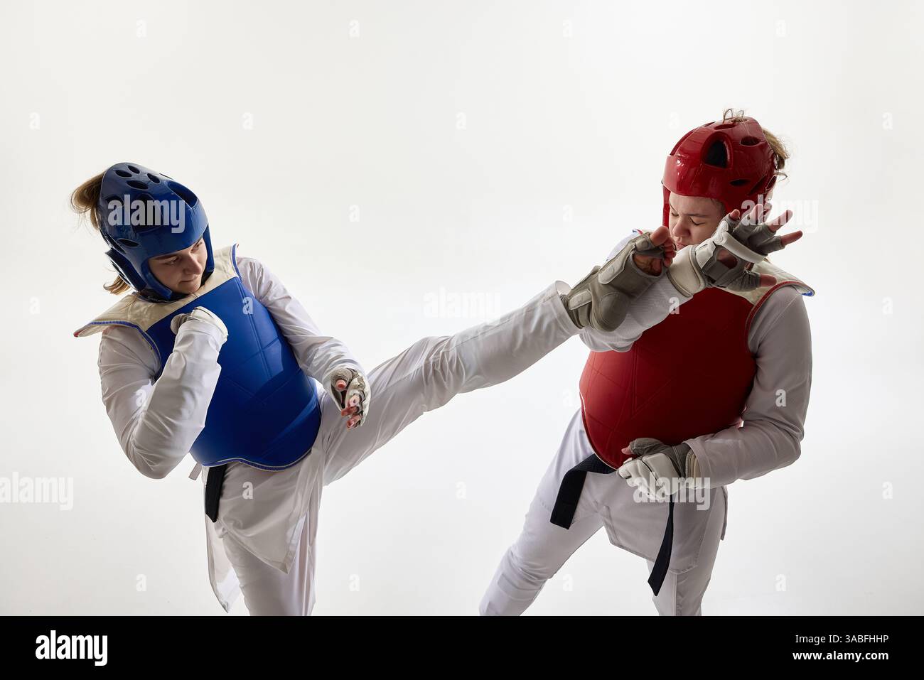 Blue taekwondo athlete landing precise kick to red opponent face during ...