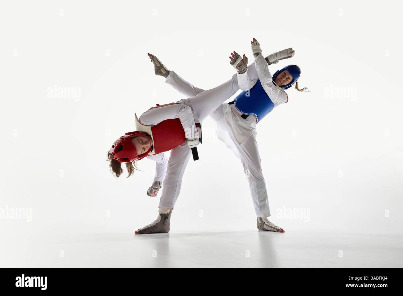 Two young women in blue and red taekwondo gear in dynamic motion ...