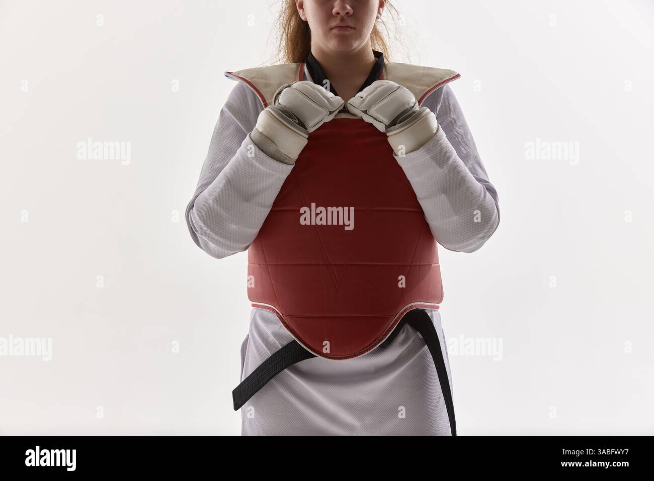 Female taekwondo athlete in red gear standing ready with closed fists ...