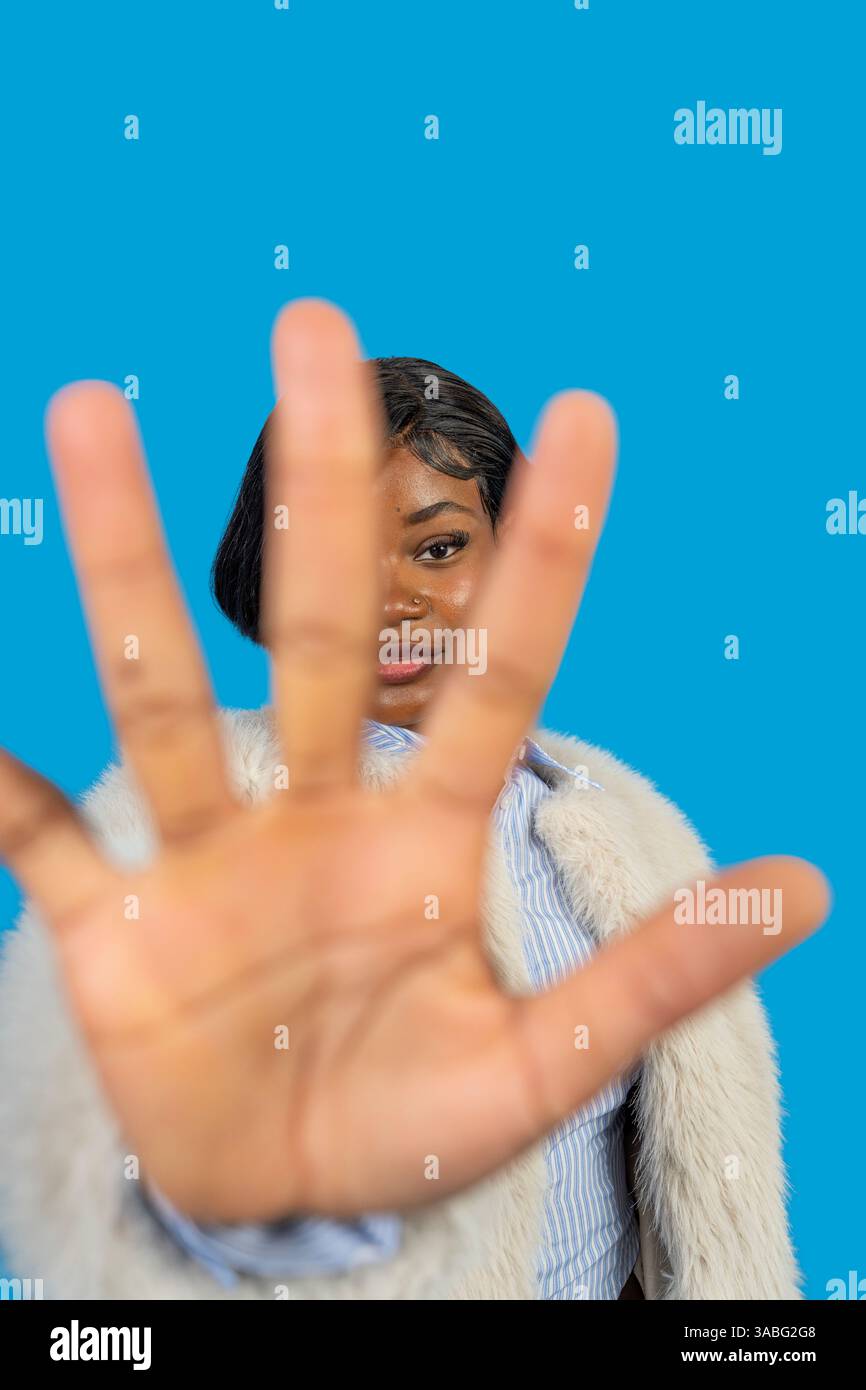 Fashion model showing stop gesture with hand covering face, expressing ...