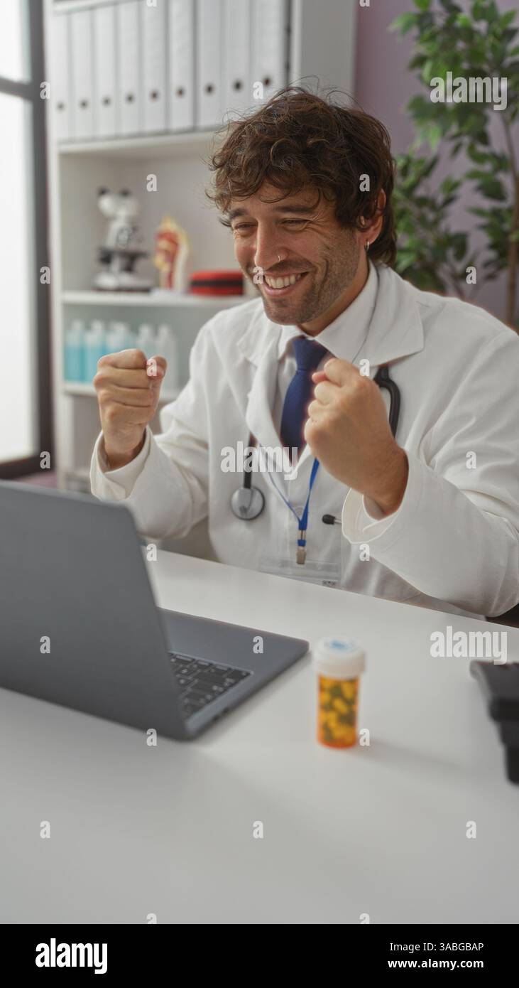 Doctor celebrating success in hospital room, smiling at laptop with ...