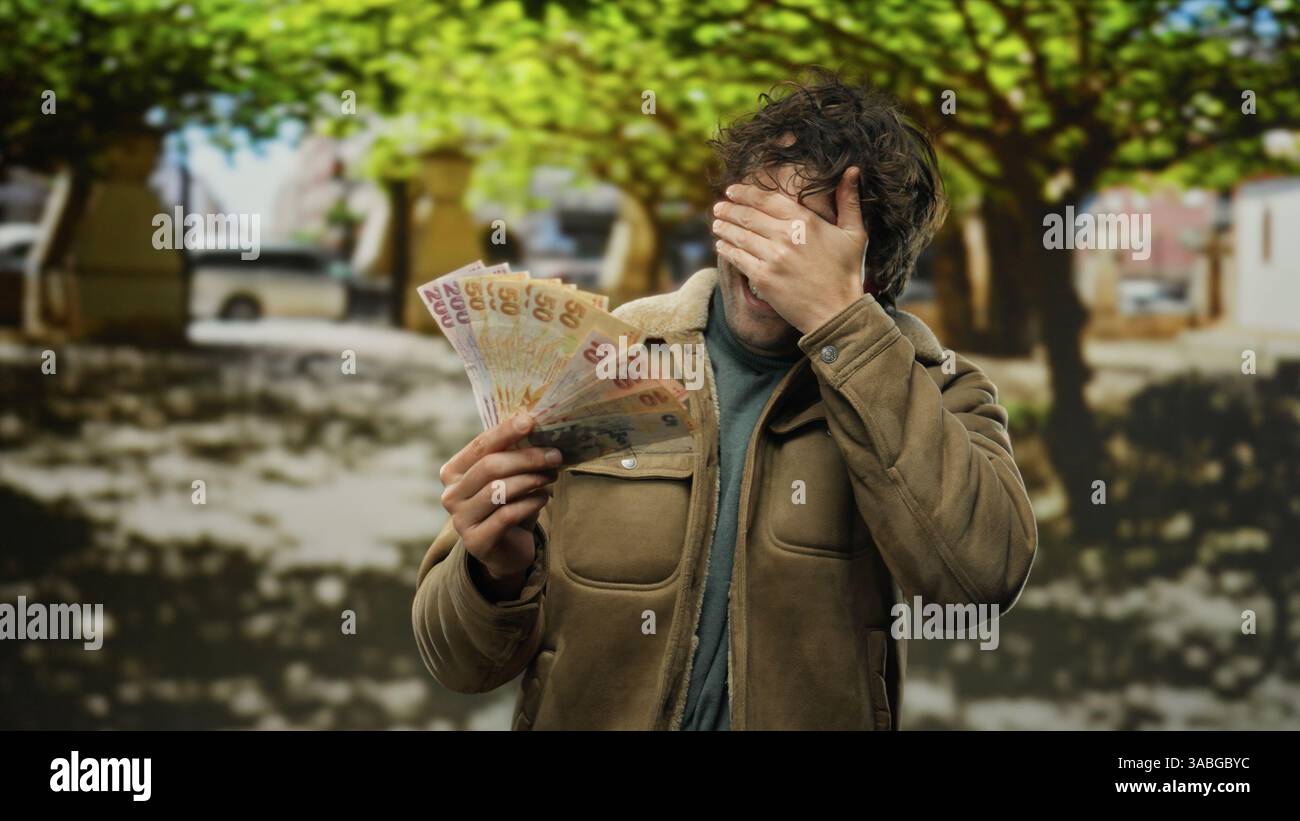 Hispanic man on city street holding turkish lira banknotes covering ...
